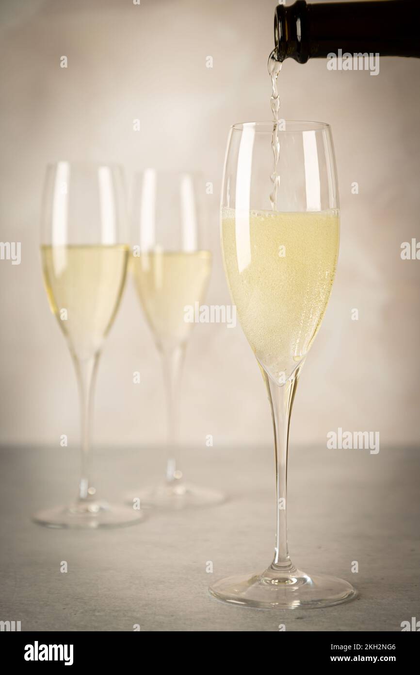 Festive photo of pouring sparkling wine into glasses Stock Photo - Alamy