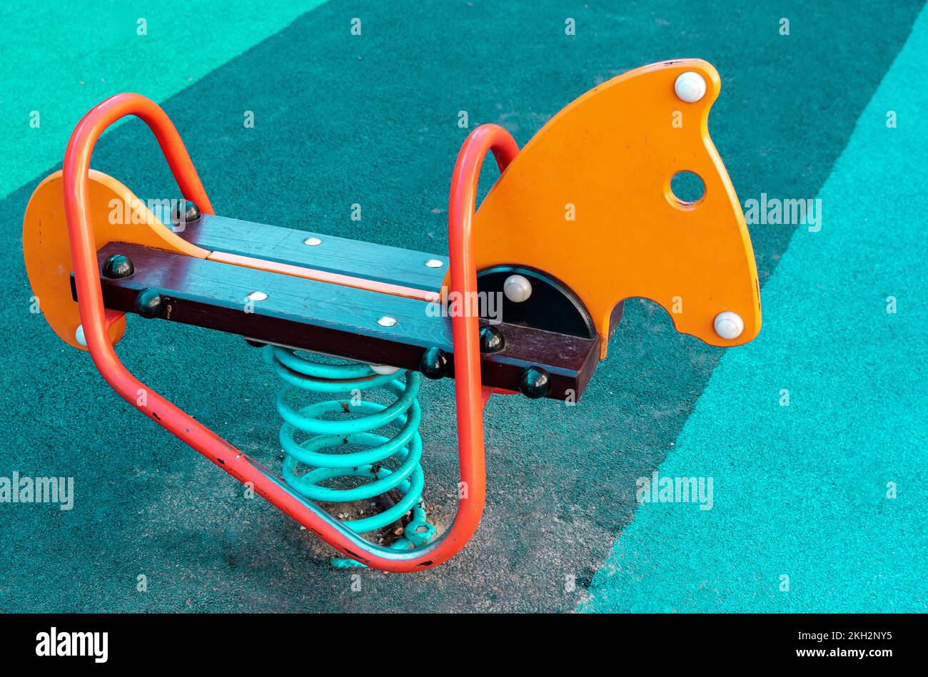 Children's playground rocking horse spring rider on blue ground, retro ...