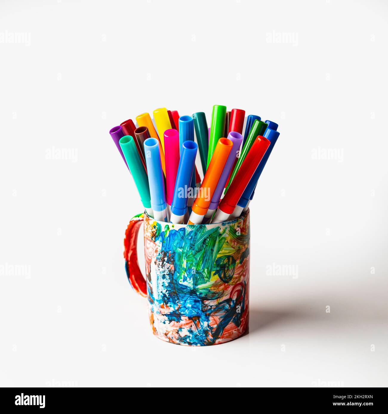 A closeup of a set of colored markers in a painted mug isolated on ...