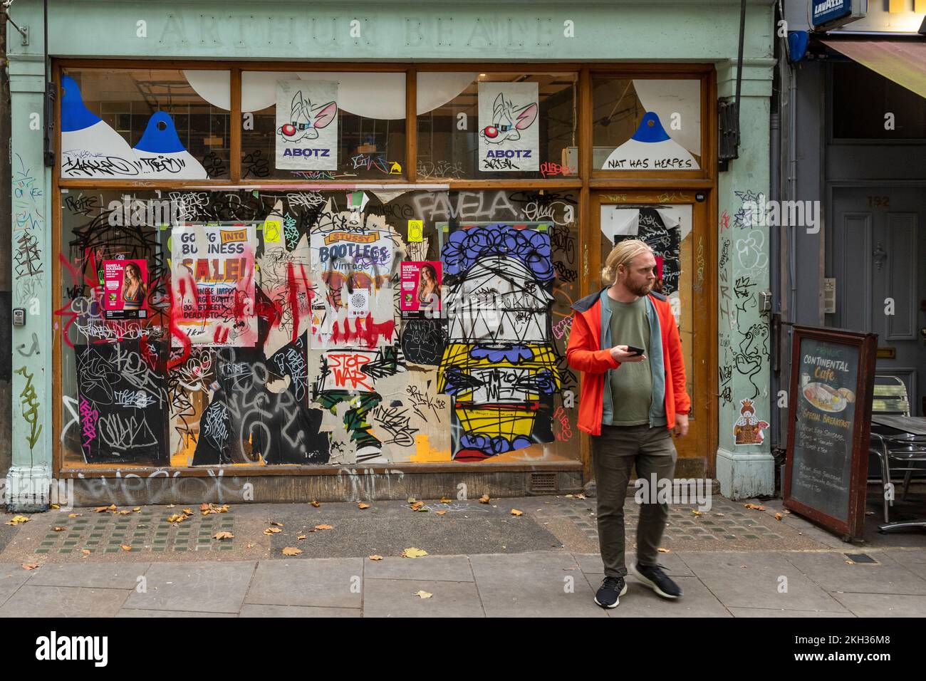 A closed down shop with its windows covered with bill posters and ...
