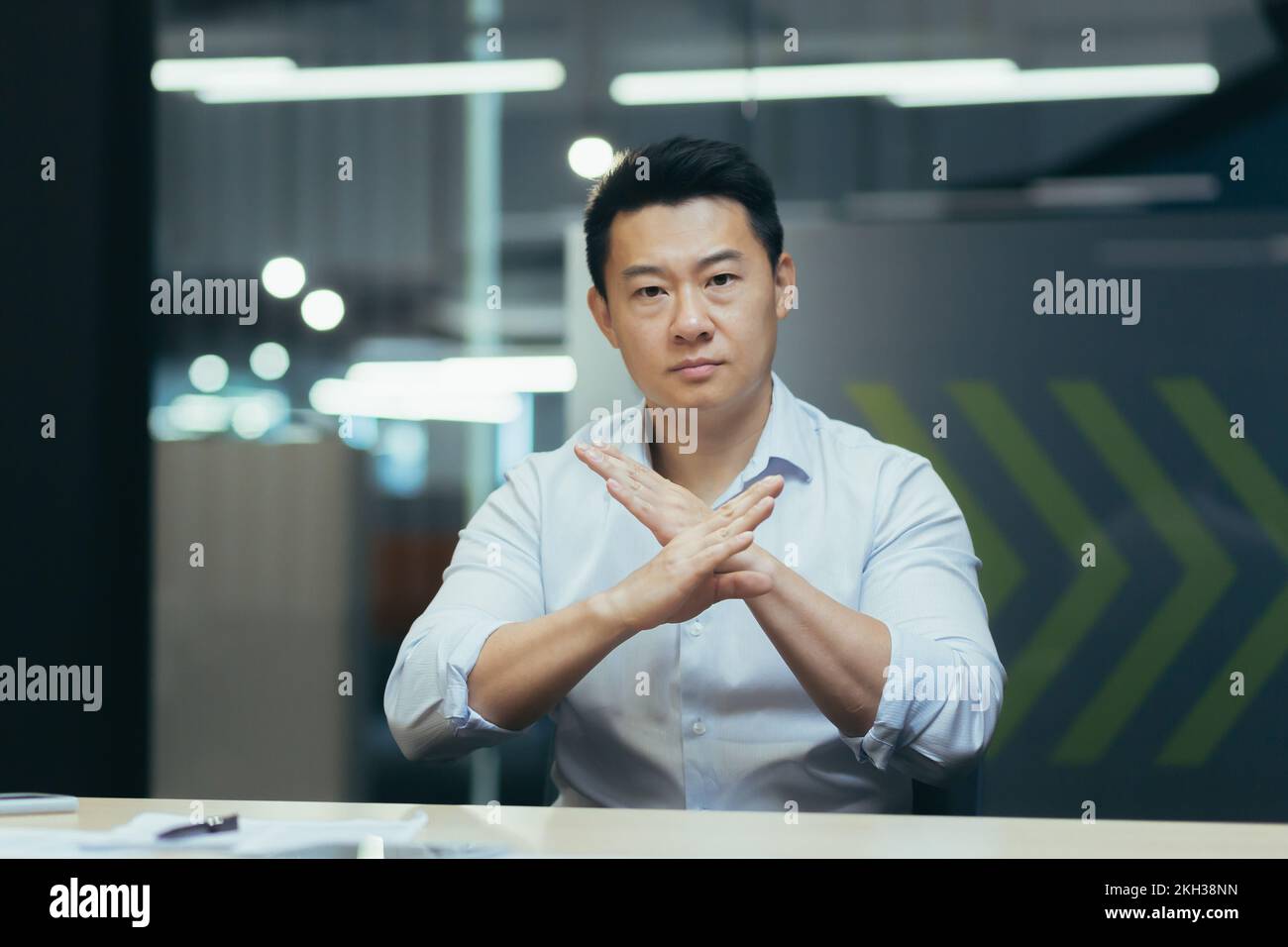 A serious young man Asian office worker sits at the desk in the office ...