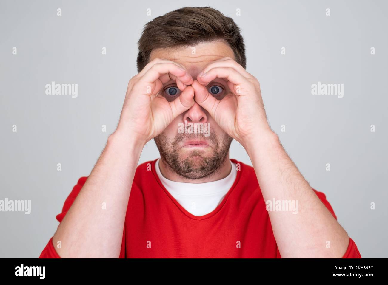 Caucasiann man making binoculars shape with his hands and looking ...