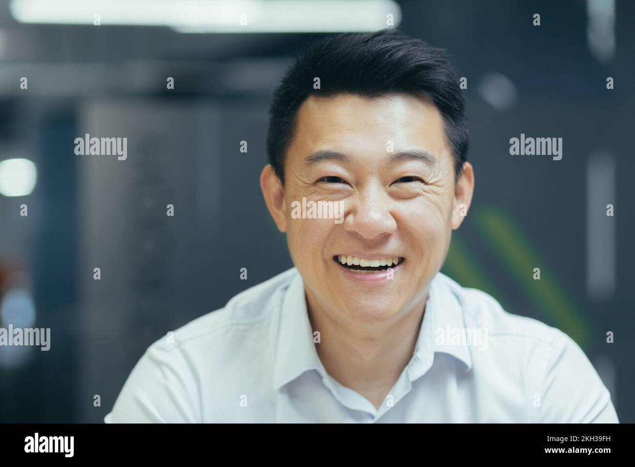 Close-up photo. Portrait of a handsome young Asian businessman. He is ...