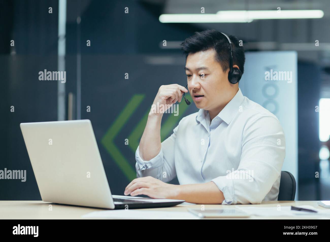 Portrait of young Asian male consultant in support service. Sitting in ...