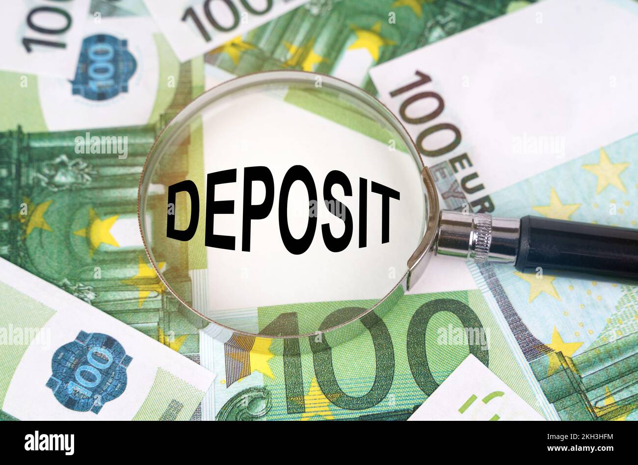 Business concept. Among the euro banknotes is a magnifying glass with ...