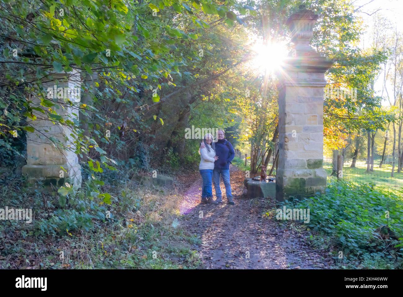 Senior couple standing their dog in background at entrance to ...