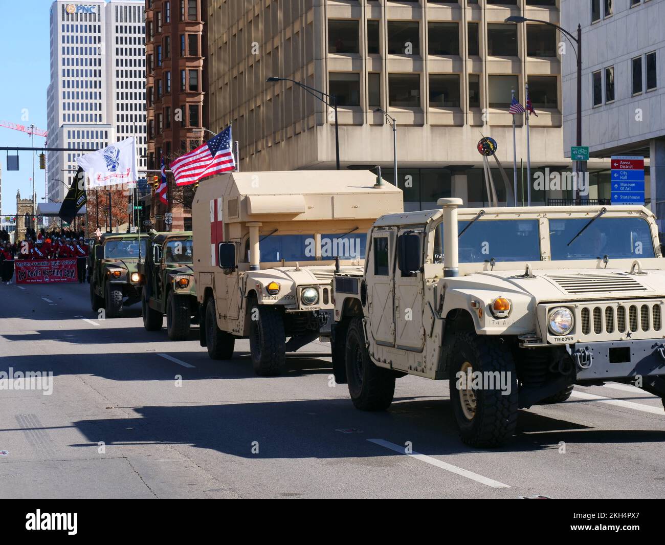 A caravan of Ohio Army National Guard tactical vehicles drive in the Columbus Veterans Day ...
