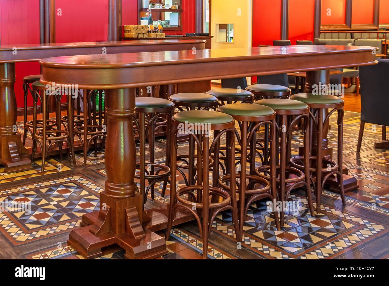Row of wooden high chairs in a bar in front of a table in a pub Stock ...