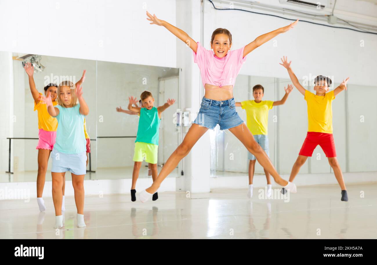 Young girls and boys jumping together in dance room Stock Photo - Alamy