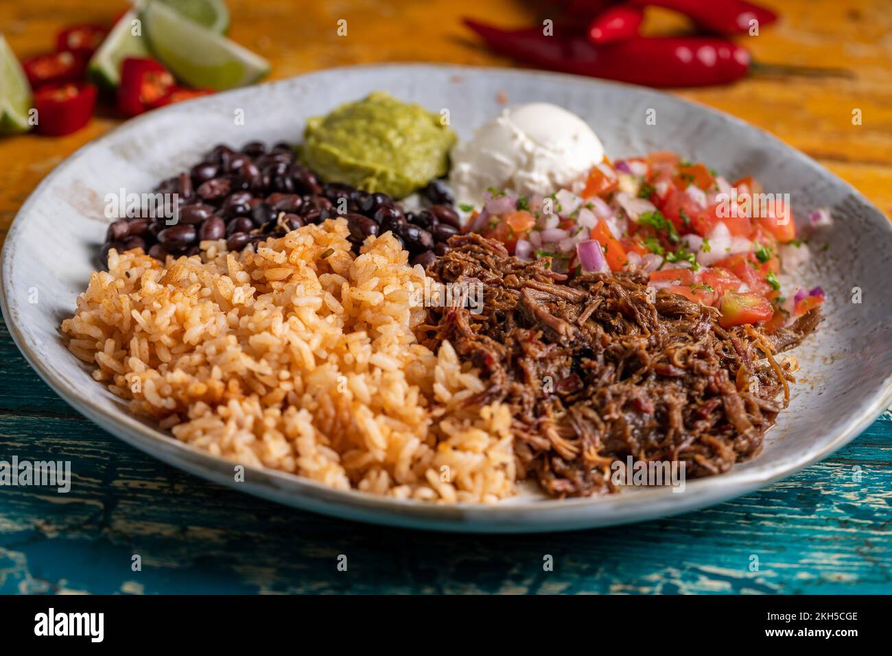 A tasty barbacoa burrito bowl, meat rice black beans sour cream ...