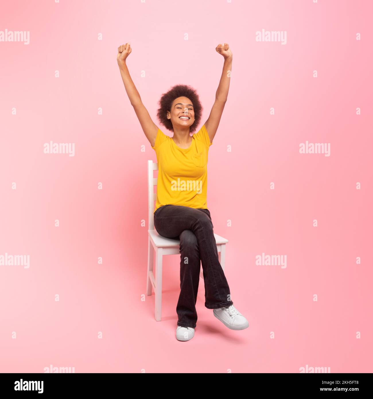 Happy young african american curly female student rejoices, makes ...