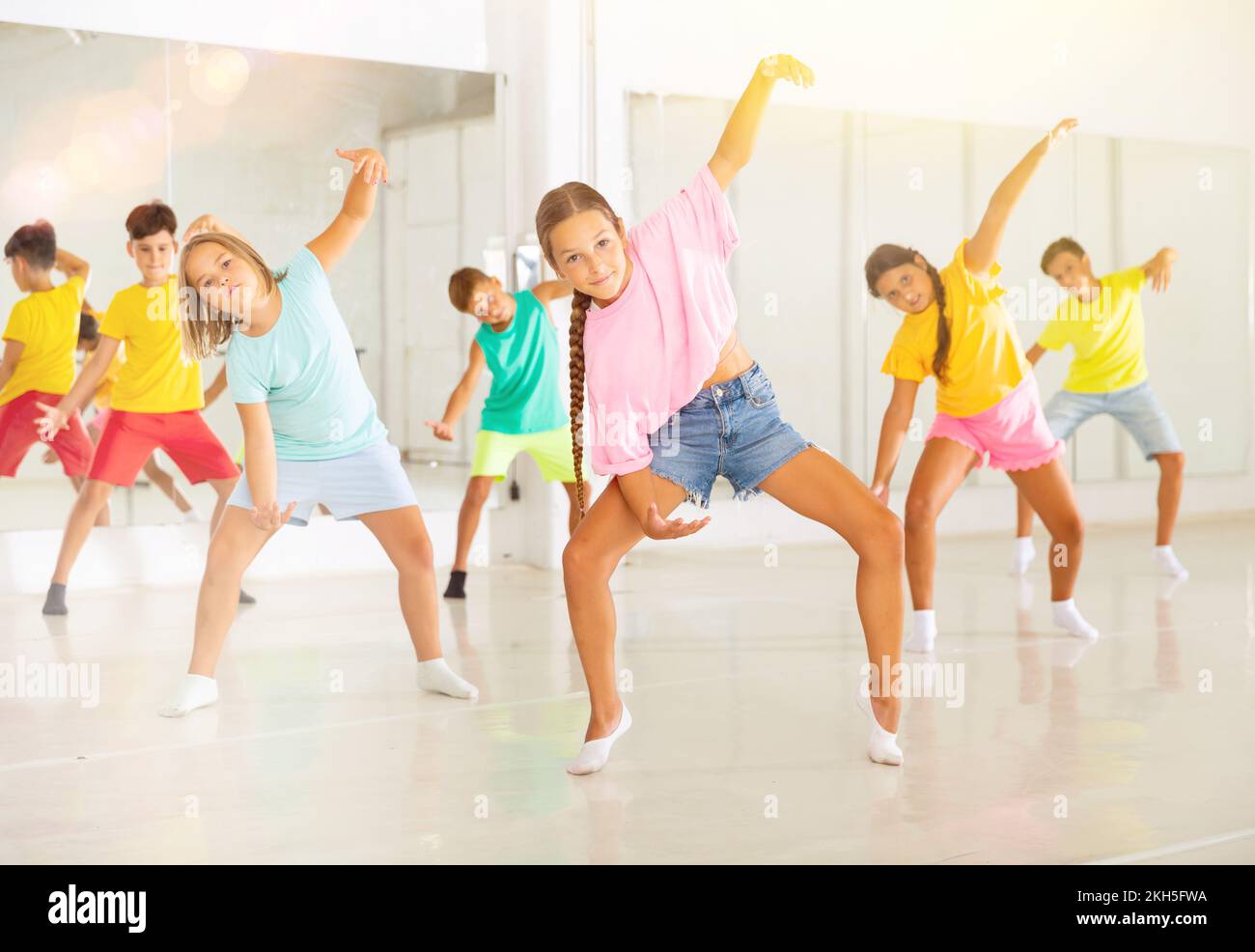 Girls and boys doing dance workout during group class in fitness center ...