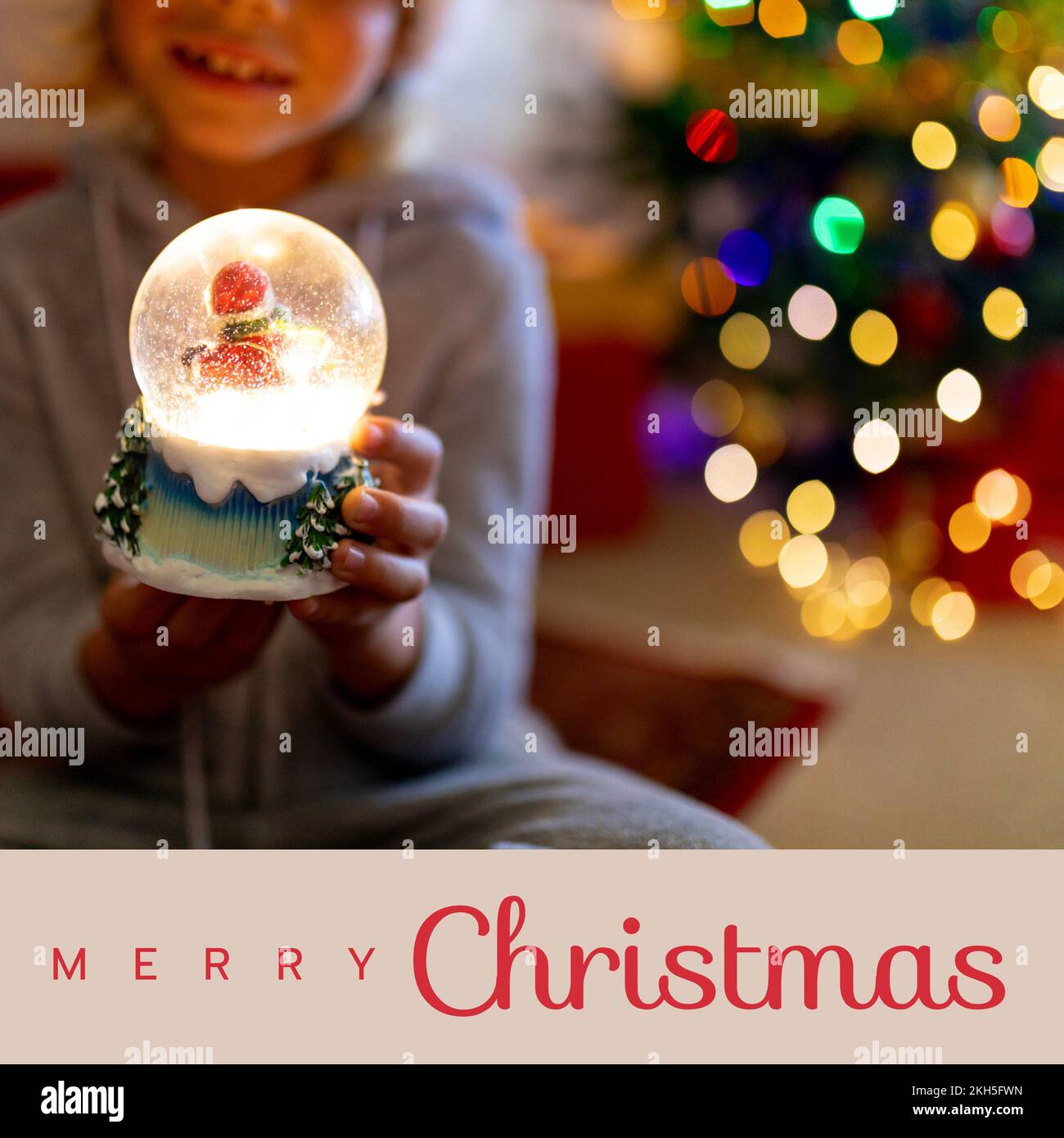 Composite of christmas greetings text over girl holding christmas snow ...