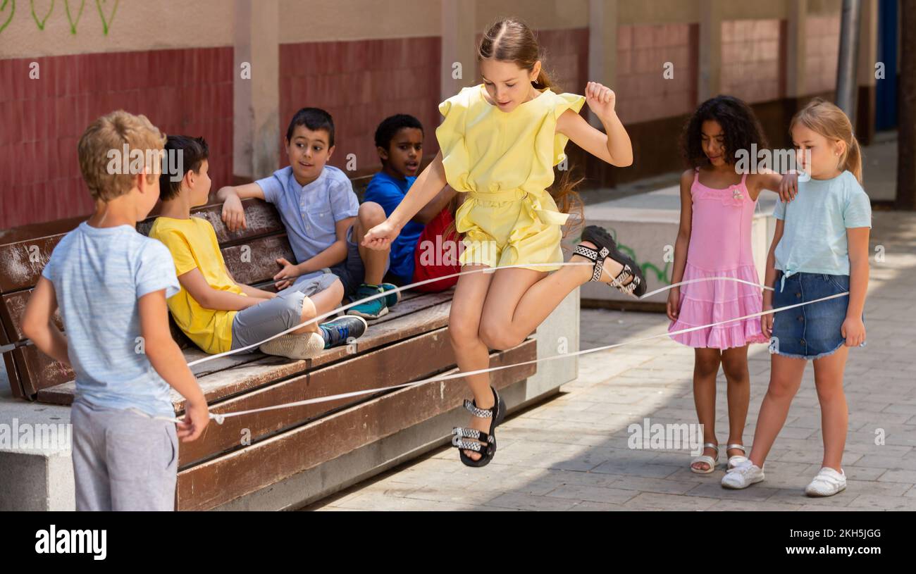 Happy smiling little friends playing with chinese jumping rope Stock Photo - Alamy