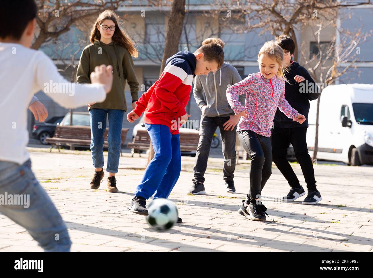 Company of glad children playing football on the street Stock Photo - Alamy