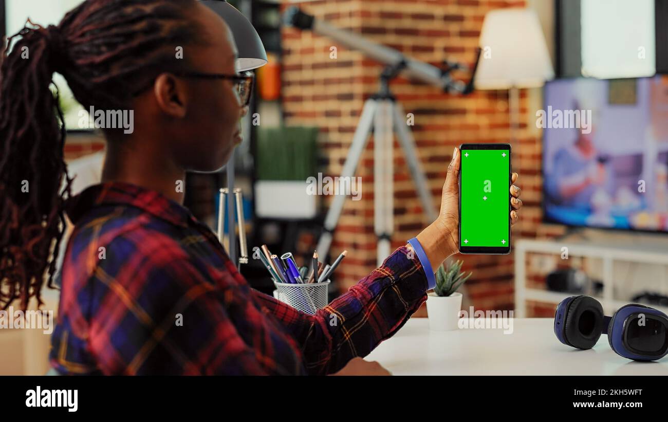 Modern person looking at greenscreen display on mobile phone, analyzing ...
