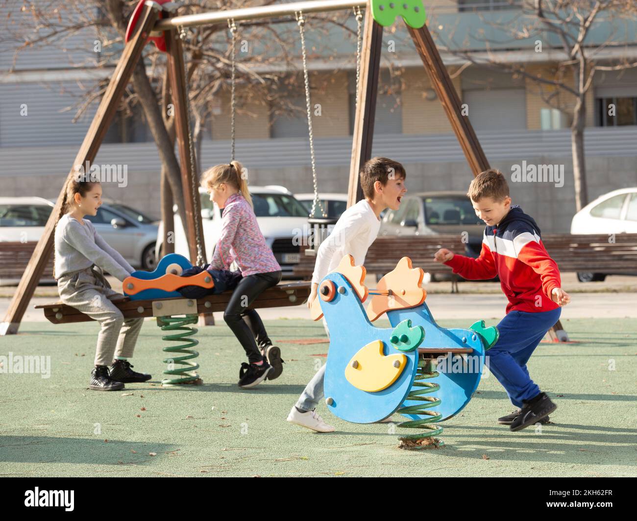 Company of kids are teetering on the swing on the playground Stock ...