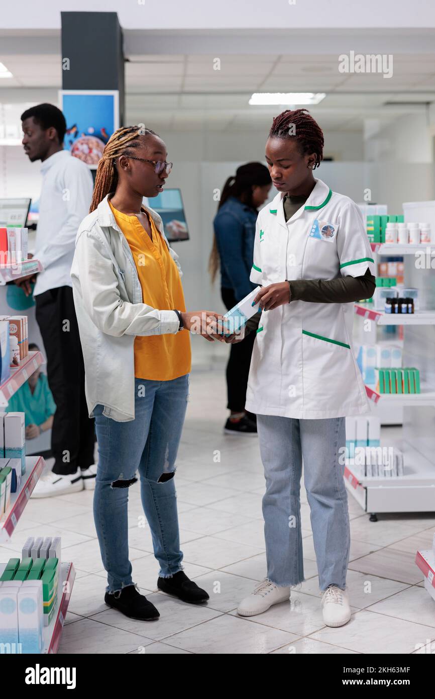 African american pharmacist helping woman choosing medications in ...
