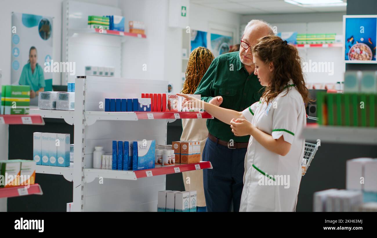 Pharmacist giving medical assistance to clients trying to buy medicine ...