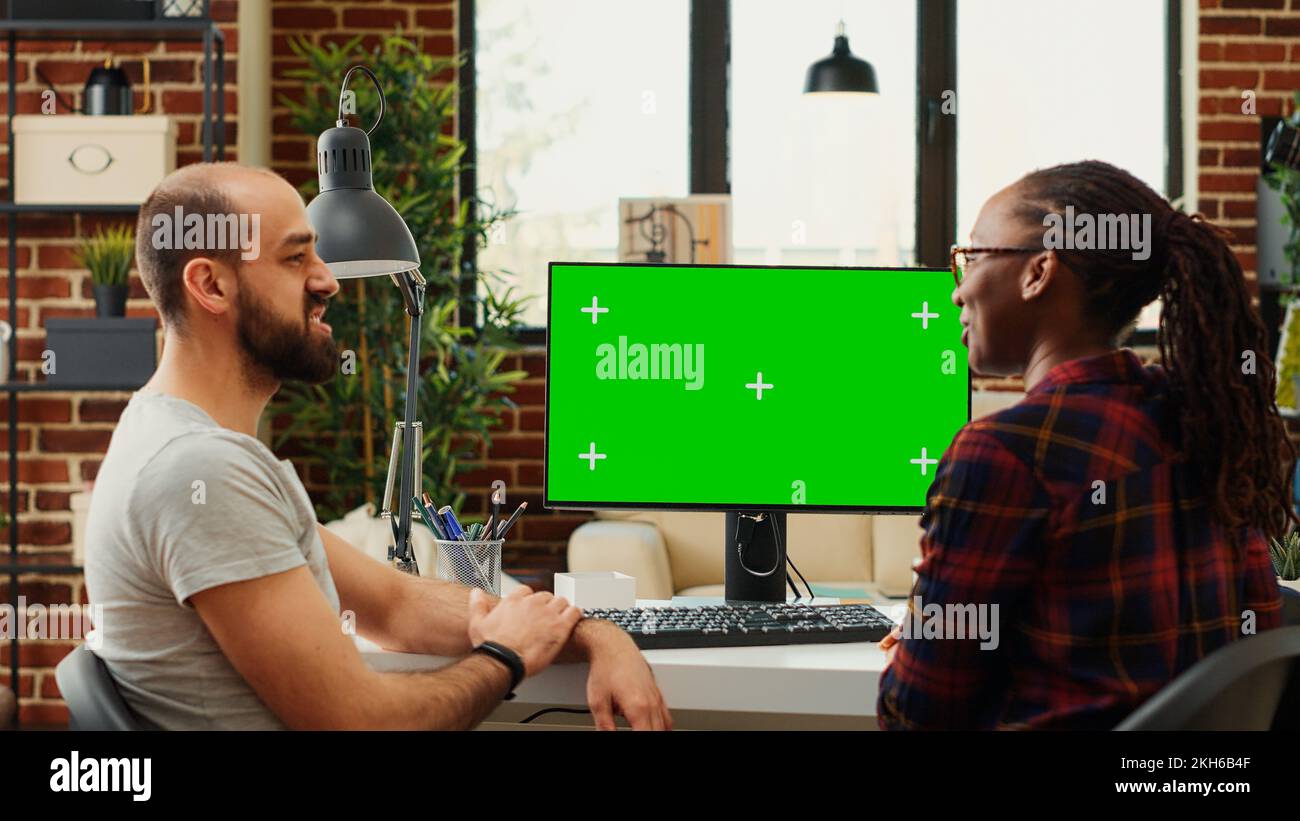 Diverse colleagues working with greenscreen display on computer, analyzing isolated chroma key ...