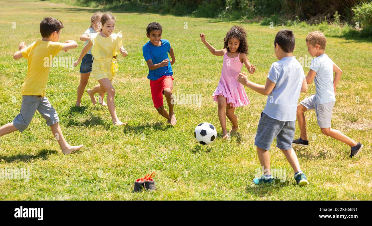 Group of happy schoolchildren playing football together Stock Photo - Alamy