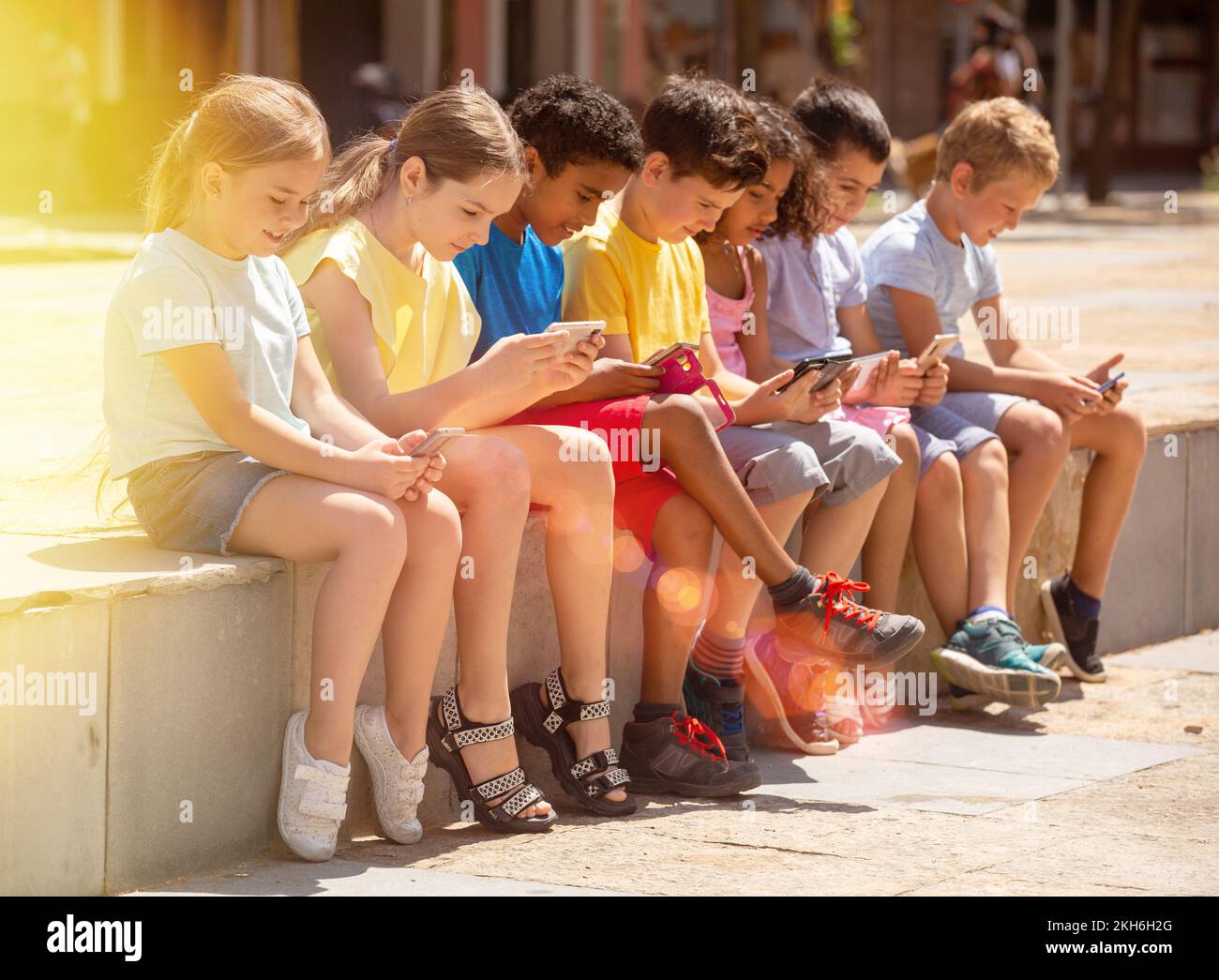 Kids using phones outdoors, concept of children addiction to network ...