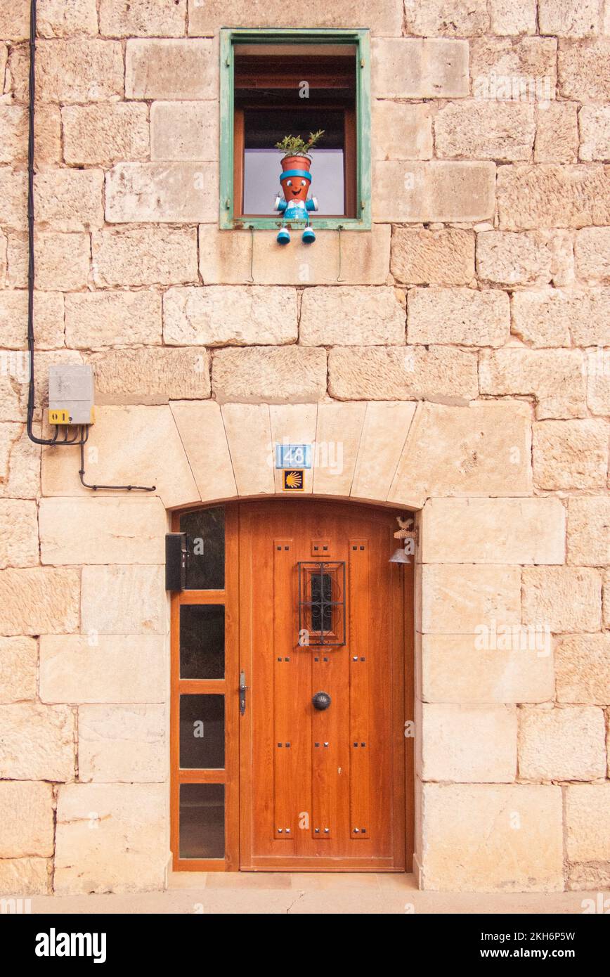 A little flower pot manikin is greeting from the window sill. A little ...