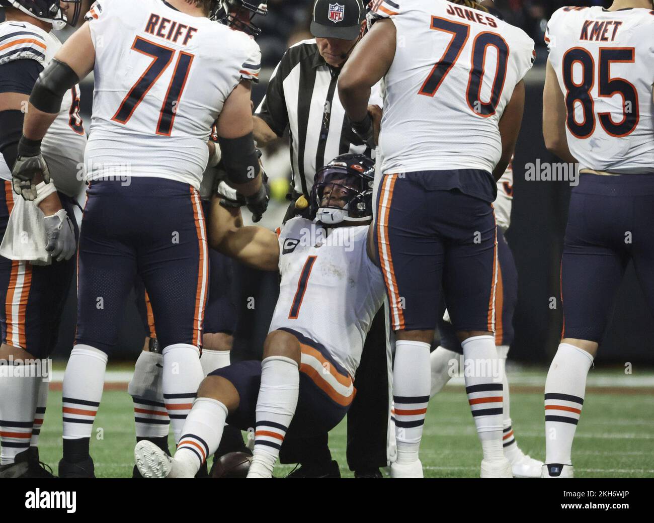 Chicago Bears quarterback Justin Fields (1) is helped to his feet by ...