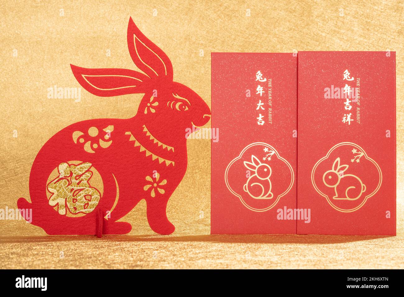 Chinese New Year of Rabbit mascot paper cut with red pockets on gold ...