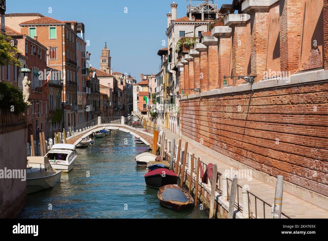 Footbridge over canal with moored boats and old architectural style ...