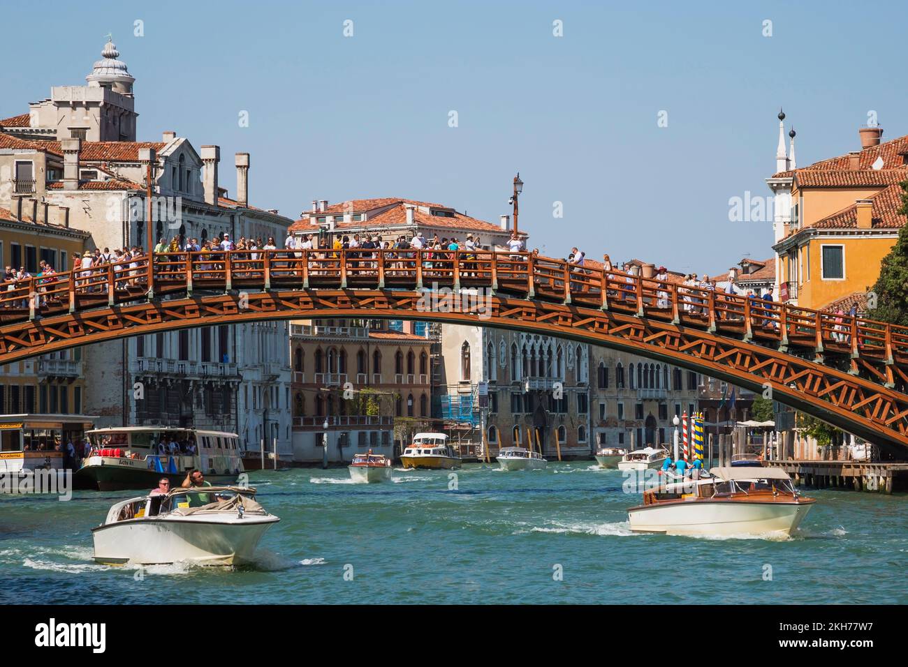 Accademia footbridge with tourists over Grand canal with water taxis ...