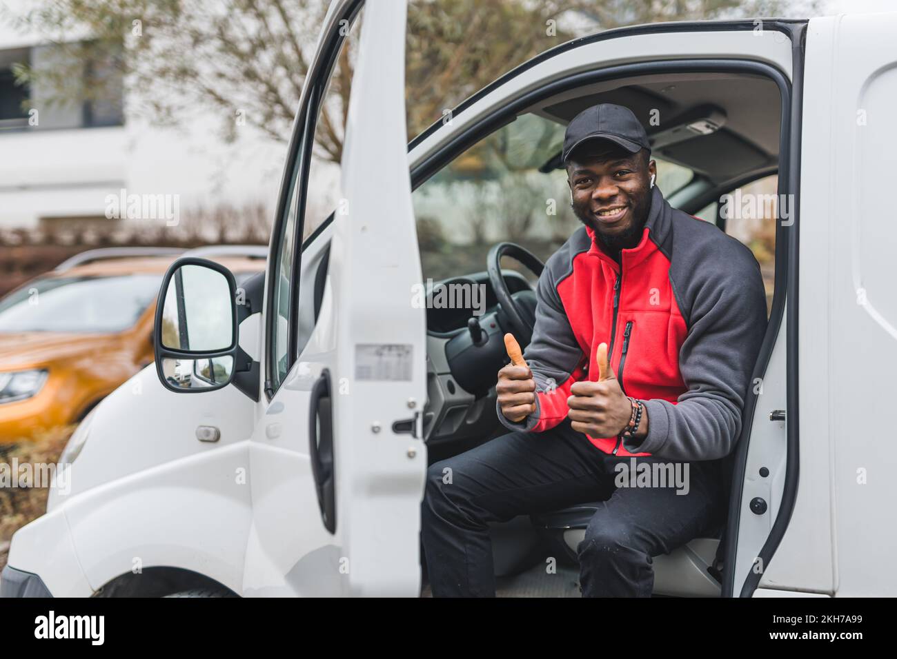 Black young adult delivery guy wearing work uniform pullover sitting in ...