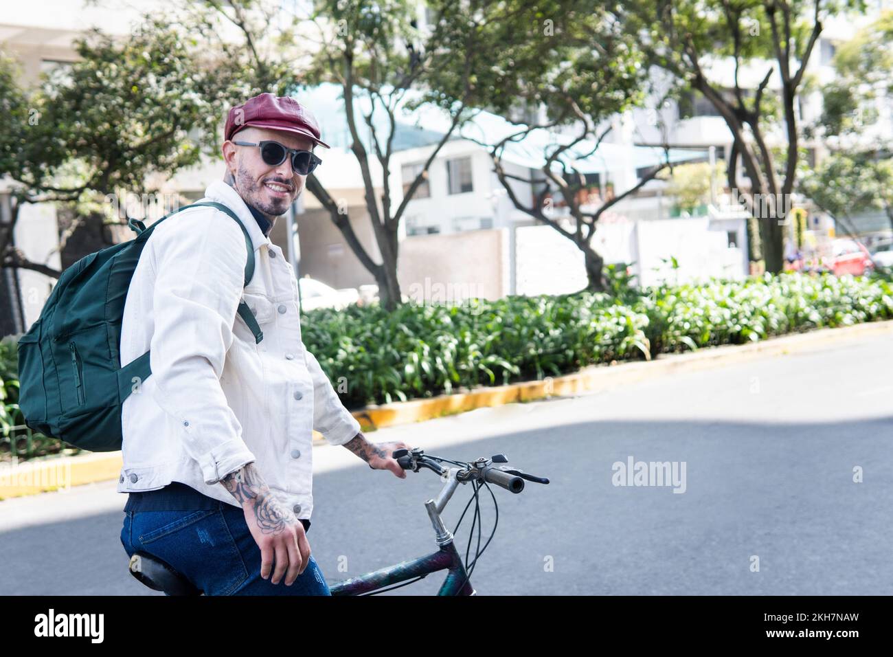 Smiling man looking at camera making a stop on his bike ride in the ...