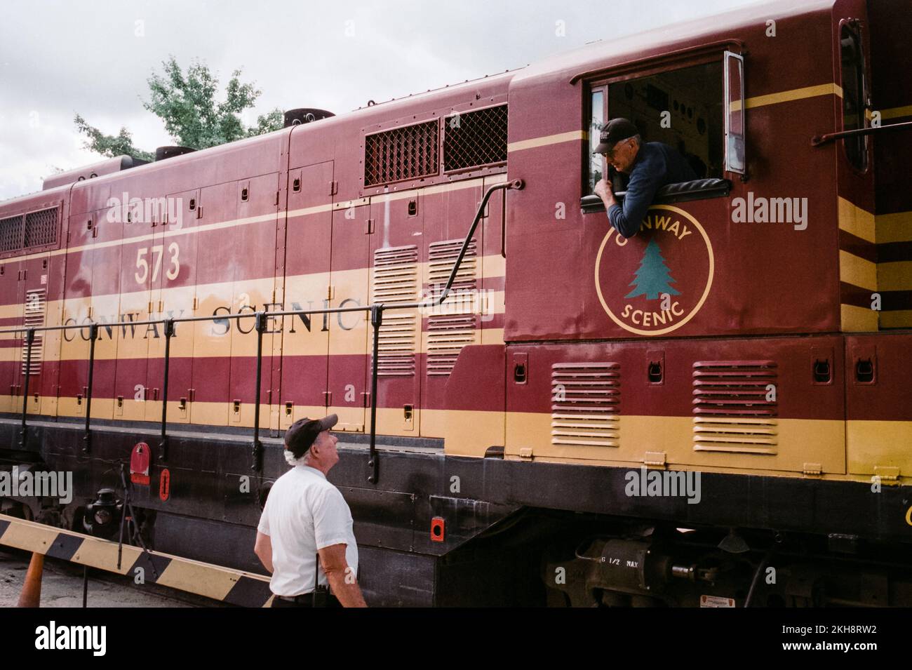 A vintage red and yellow diesel train engine in the crossing with the ...
