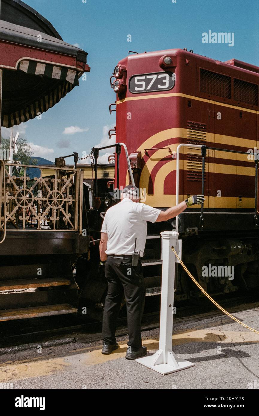 A vintage red and yellow diesel train engine in the crossing with the ...