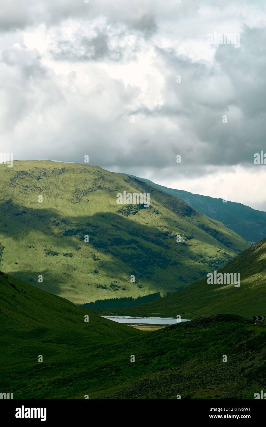 A vertical shot of green Scottish Highlands under the cloudy sky Stock ...
