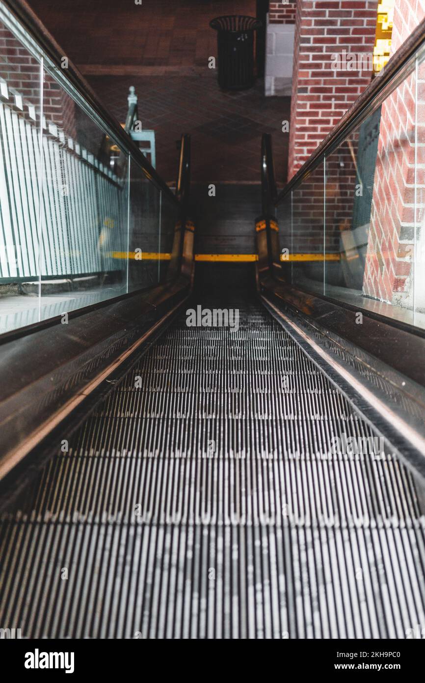 A vertical shot of an escalator going down through a building with ...