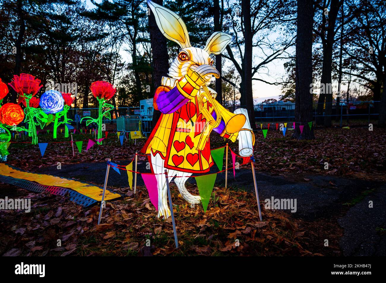 A glowing colorful light statue of a long-eared white rabbit playing ...
