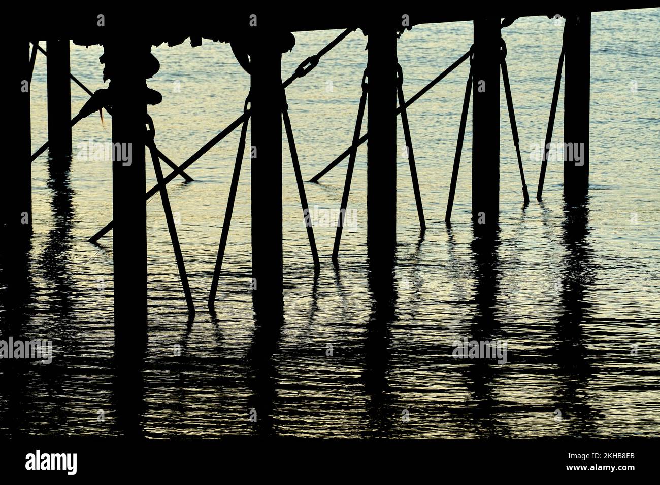 A beautiful view of a pier reflection on water during sunrise Stock ...