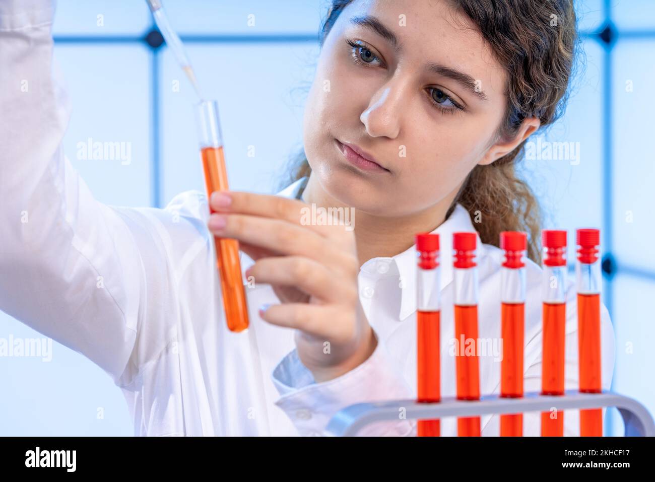 young adult female student in a science laboratory with chemical ...