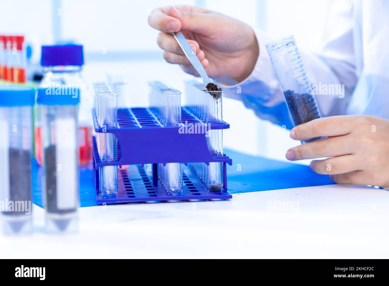 young adult woman in a chemical laboratory conducts a chemical analysis ...