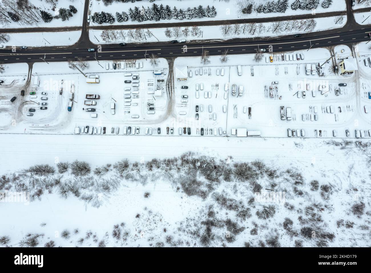 parking lot with snow-covered cars near residential area in wintertime ...