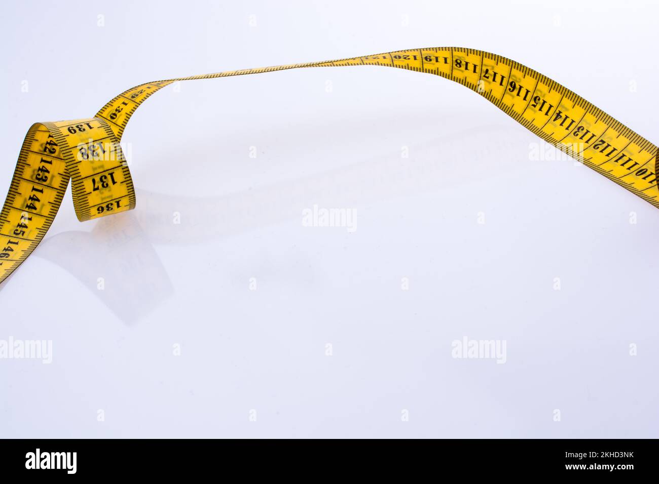 Yellow color measuring tape on a white background Stock Photo - Alamy