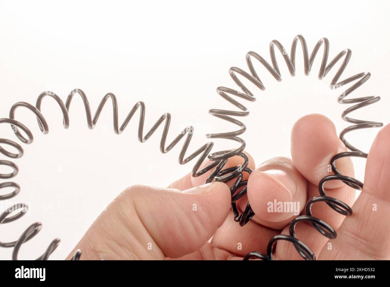 Metal spring form a heart shape in hand on a white background Stock ...