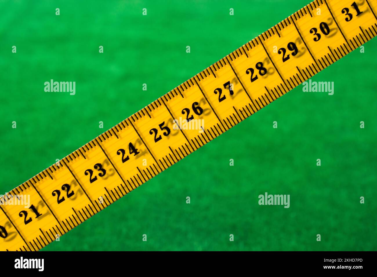 Yellow color measuring tape on green grass Stock Photo - Alamy