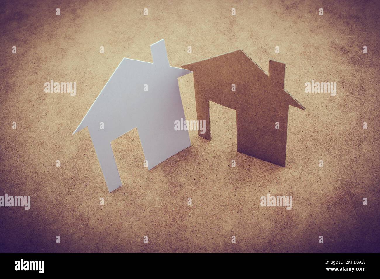 Little paper houses on a brown background Stock Photo - Alamy