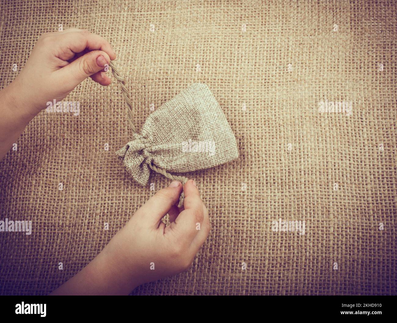 Hand holding an empty little sack made of linen Stock Photo - Alamy
