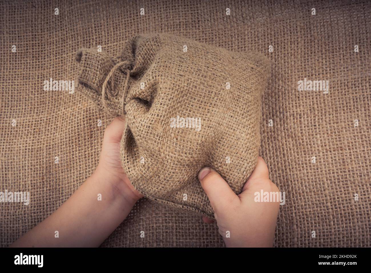 Hand holding an empty little sack made of linen Stock Photo - Alamy