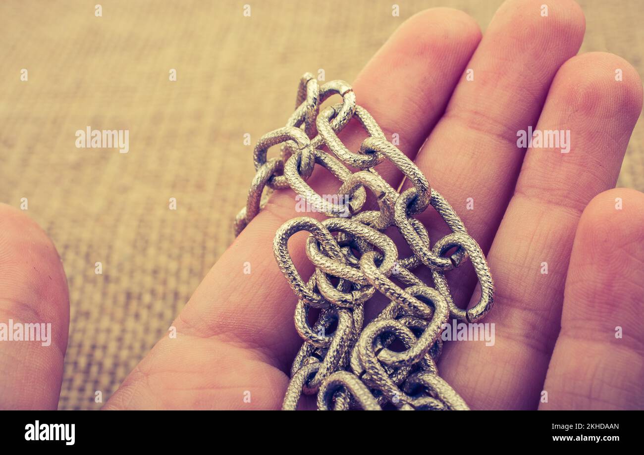 Chain made of gold color in hand Stock Photo - Alamy