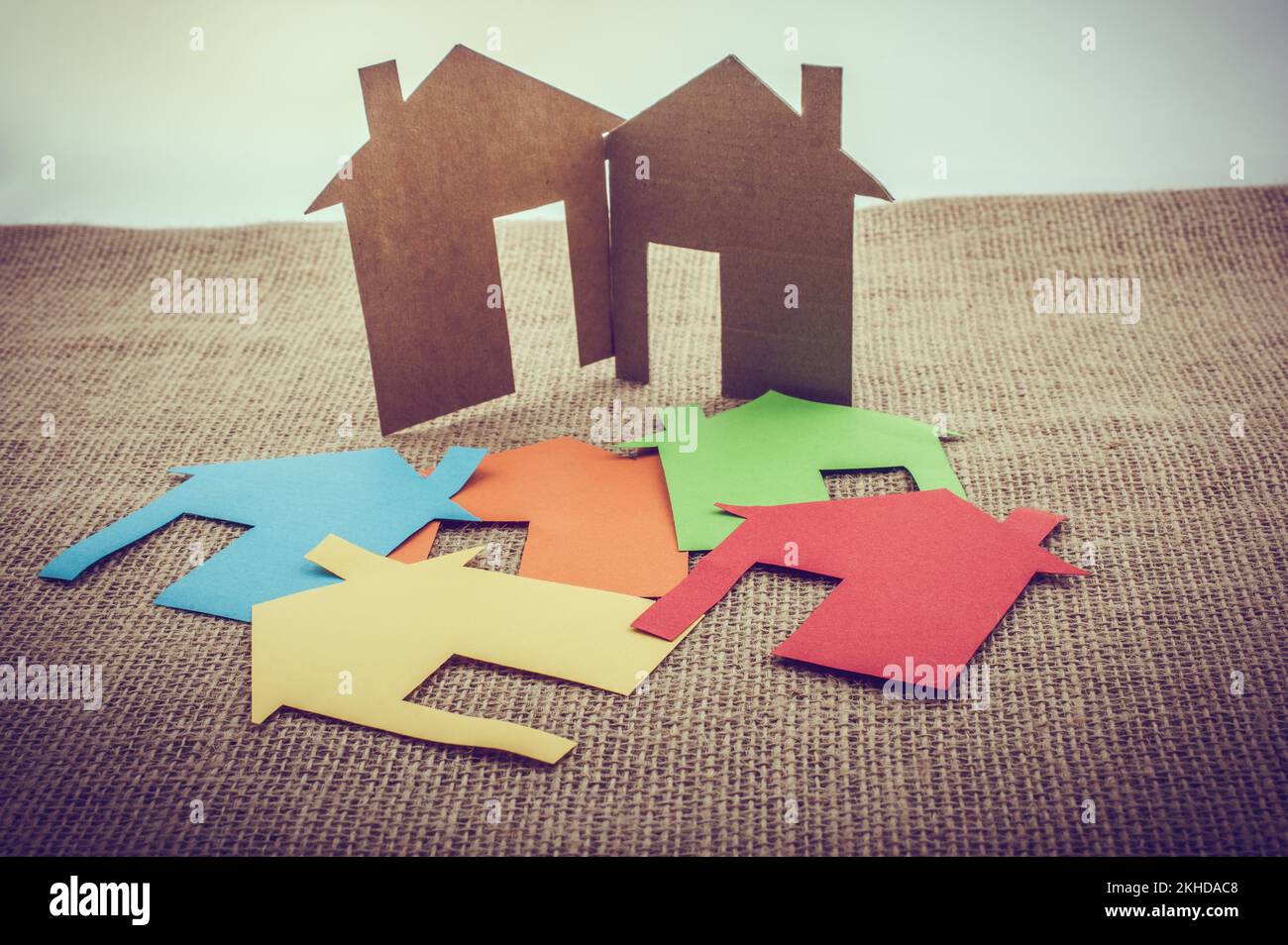 Little house shape cut out of colorful paper on a canvas background ...